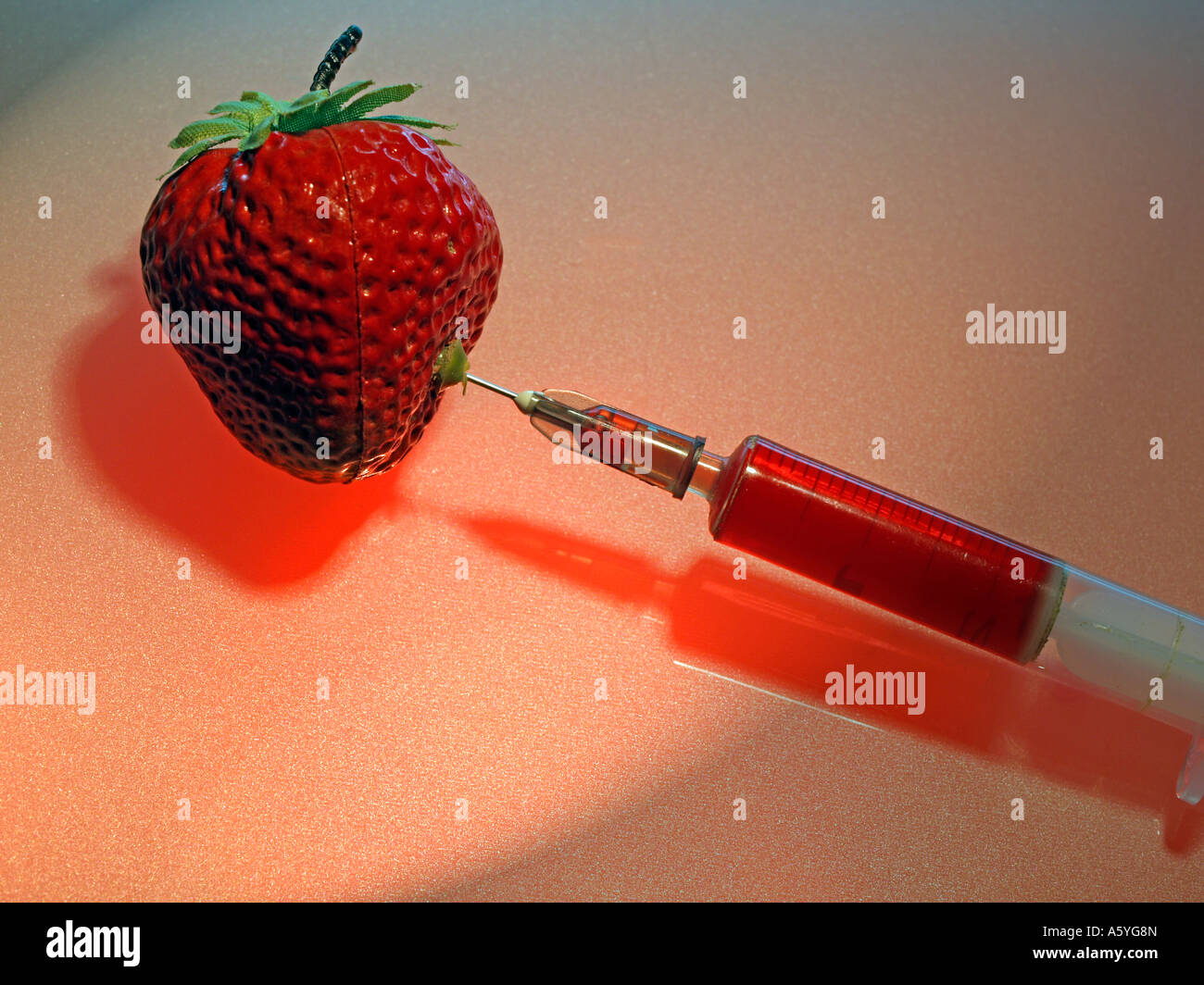 injection syringe shot with red fluid liquid in an artificial ...