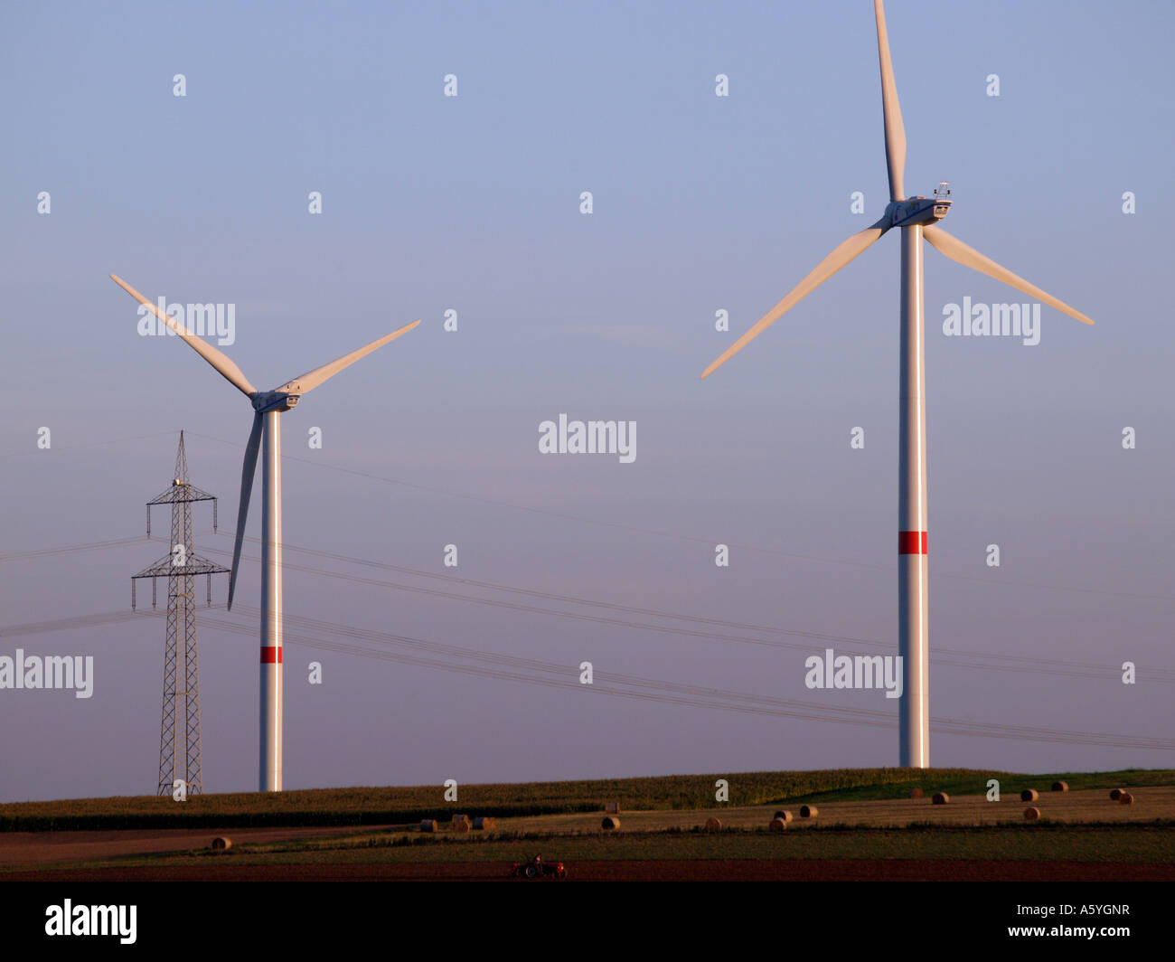 wind power station wind wheels in front of power pylon Stock Photo - Alamy