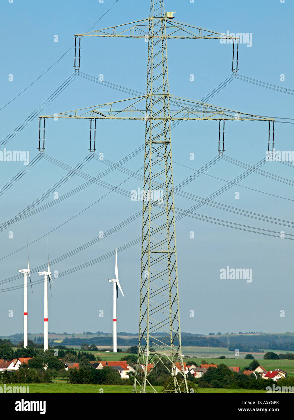 wind power station wind wheel behind power lines in country landscape ...