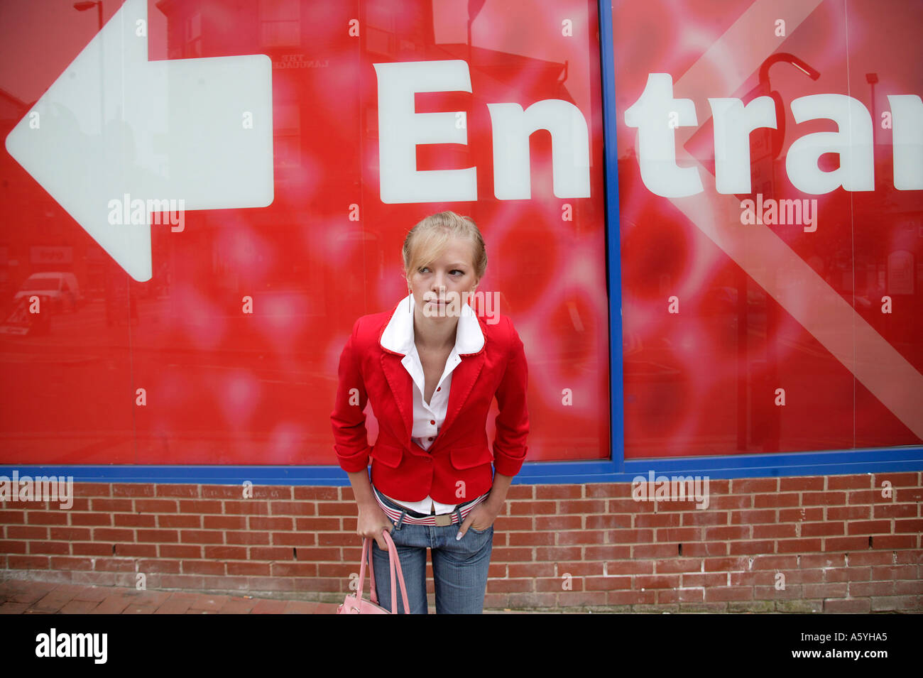 YOUNG WOMAN IN FRONT OF SHOP ENTRANCE SIGN Stock Photo - Alamy