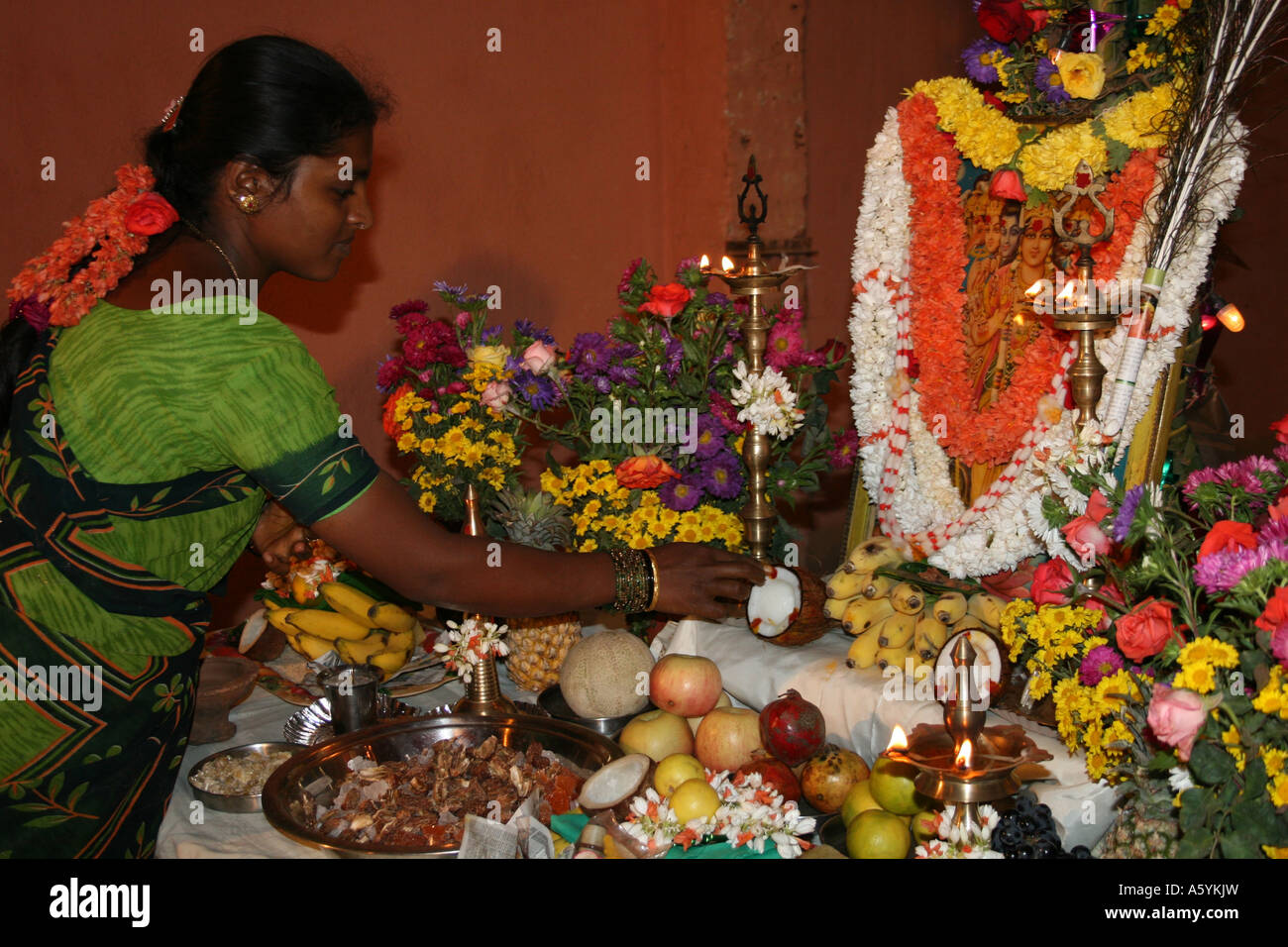 Woman gives pooja offerings at a shrine for the Karaga Festival ...