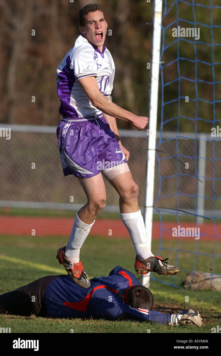 Soccer Footballer celebrating a score as he jumps over the defeated ...