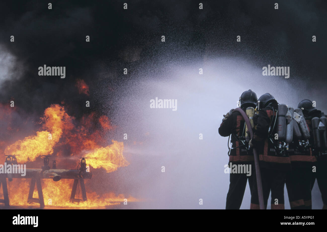 Fire-fighters putting out flames Stock Photo - Alamy