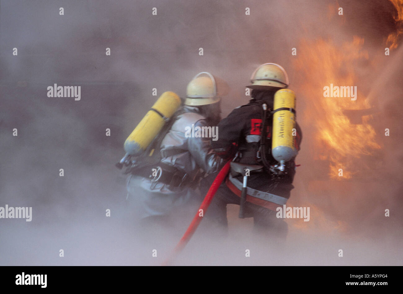 Fire-fighters putting out flames Stock Photo - Alamy