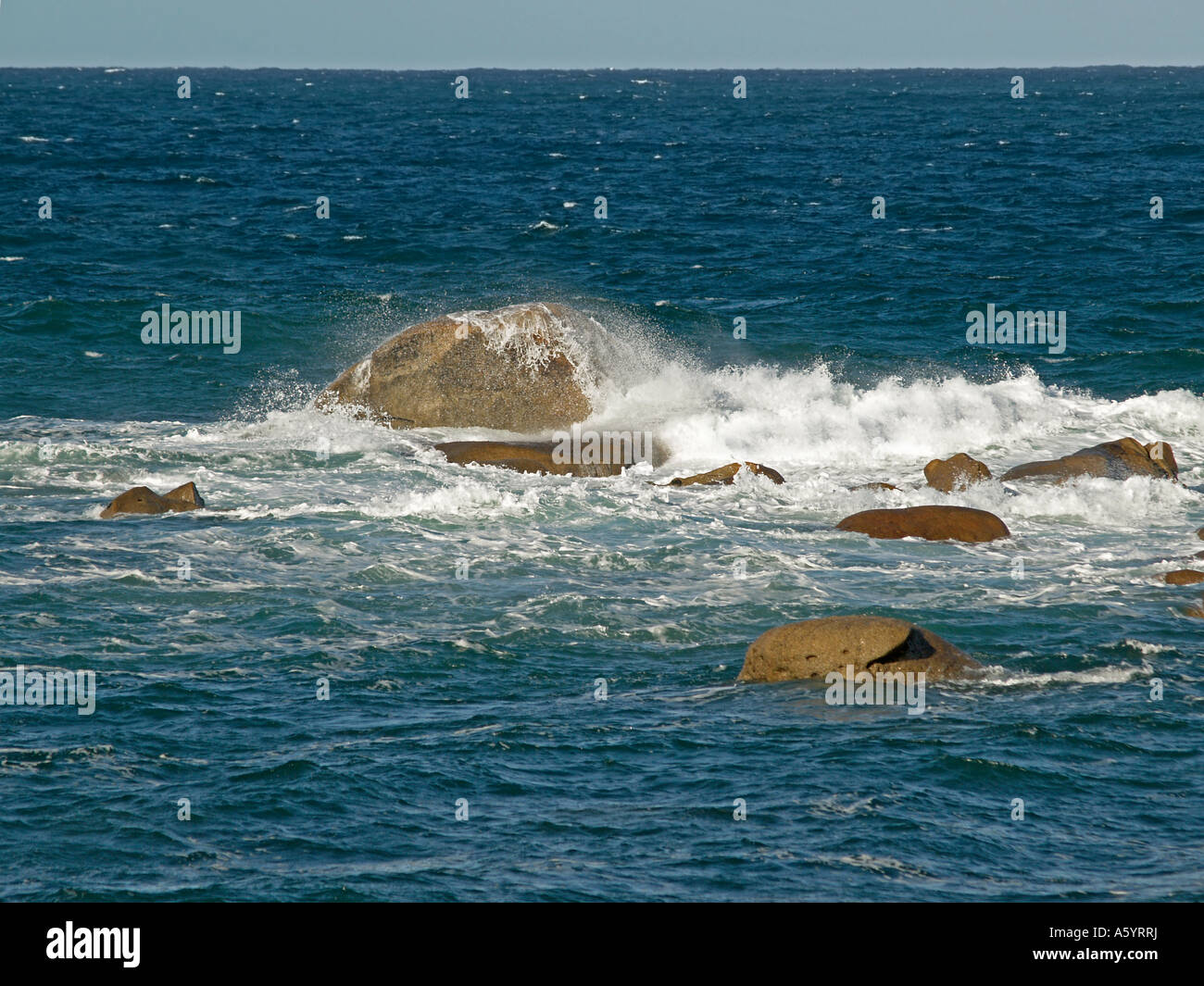 wash of the waves at stony strand with granit rocks on the coast in ...