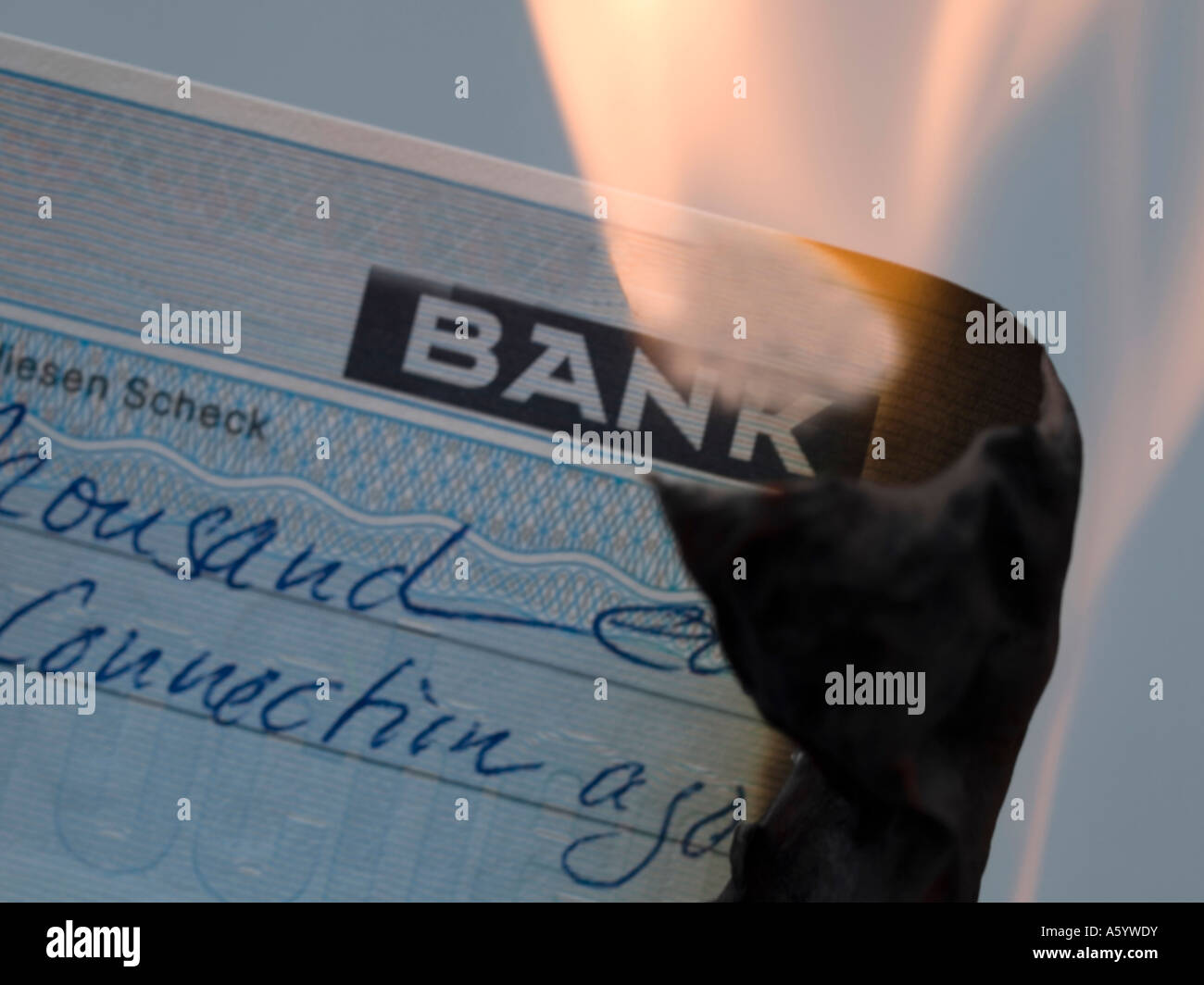 hand holding a burning cheque eurocheque Stock Photo - Alamy