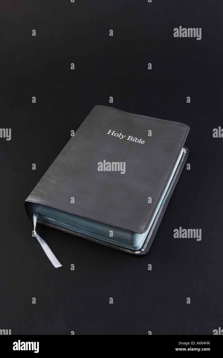 Holy Bible with gray cover on black vertical background Stock Photo - Alamy