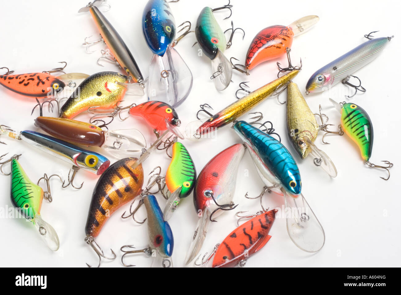 Brightly colored assorted artificial fishing lures on white horizontal ...