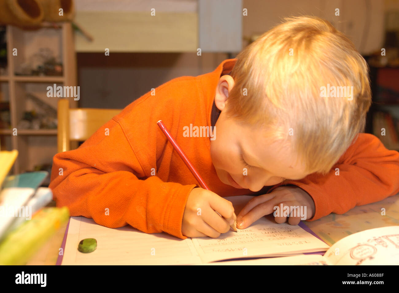 Little boy doing homework writing Stock Photo - Alamy