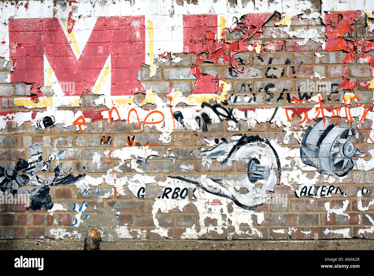 Graffiti over an old motor mechanics advert on a wall in Carpenters ...