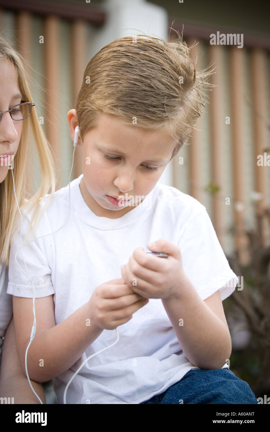 A happy brother and sister listen to a music player together Stock ...