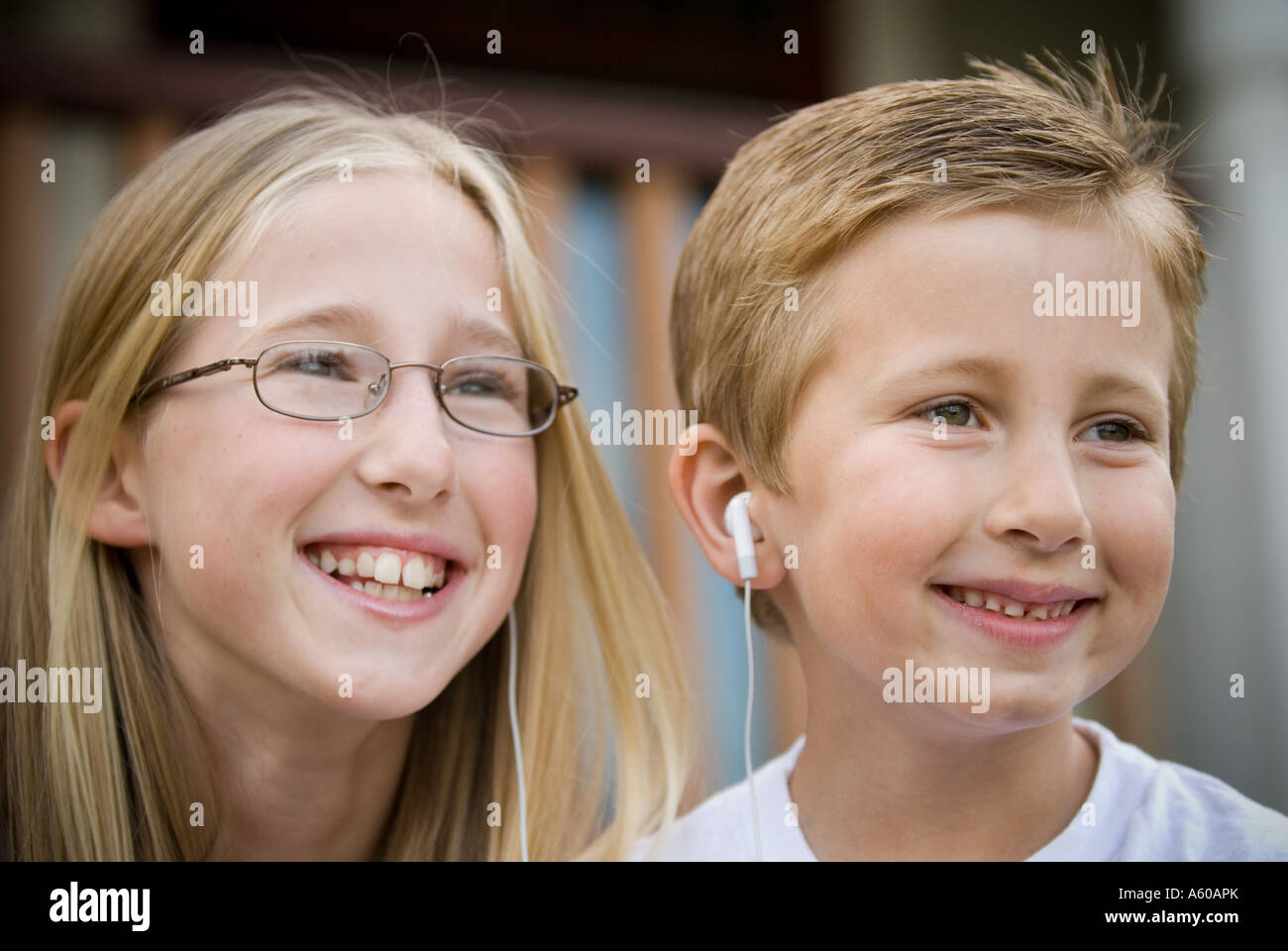 A happy brother and sister listen to a music player together Stock ...
