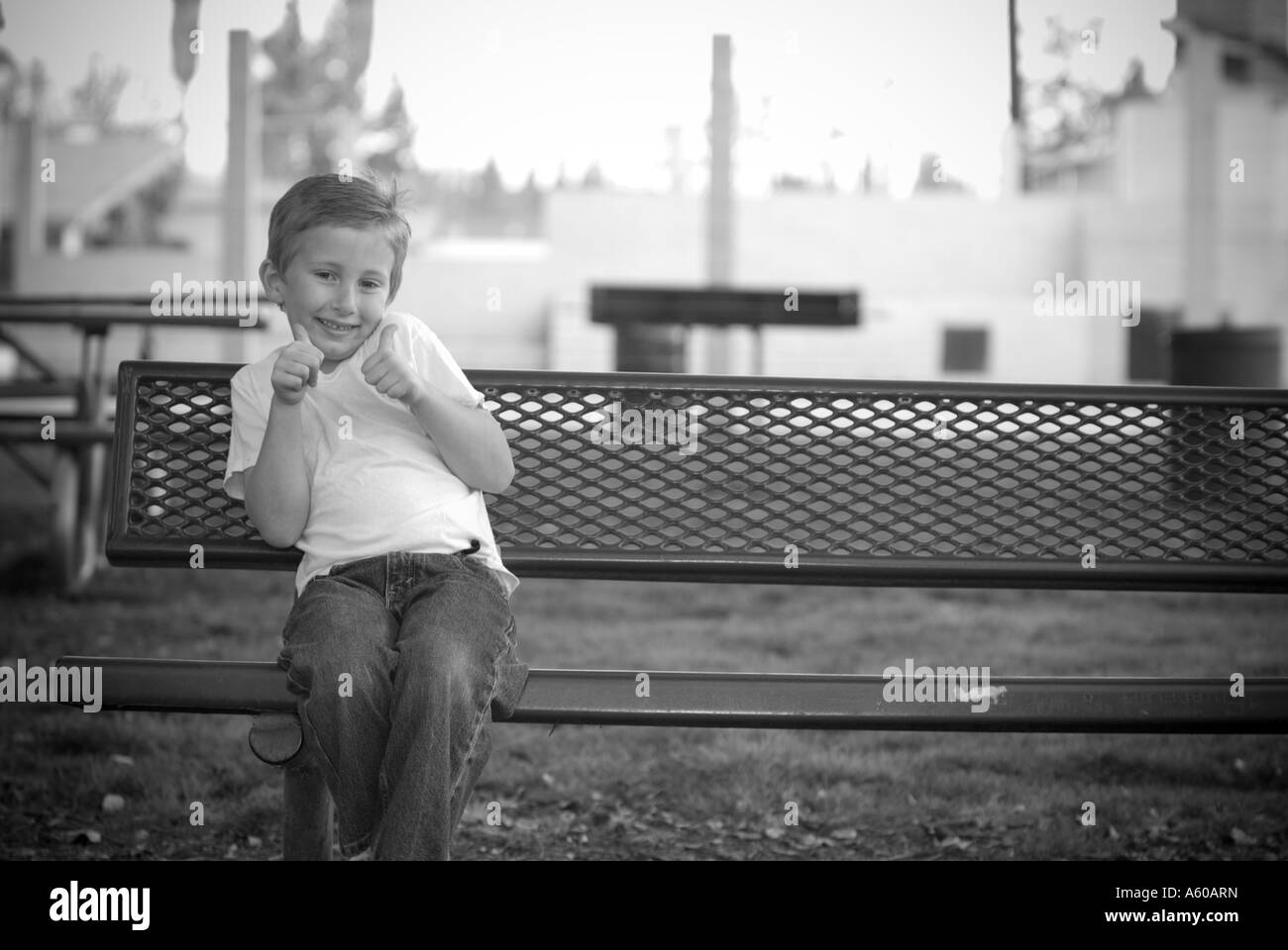 Cute kid on a park bench Stock Photo - Alamy