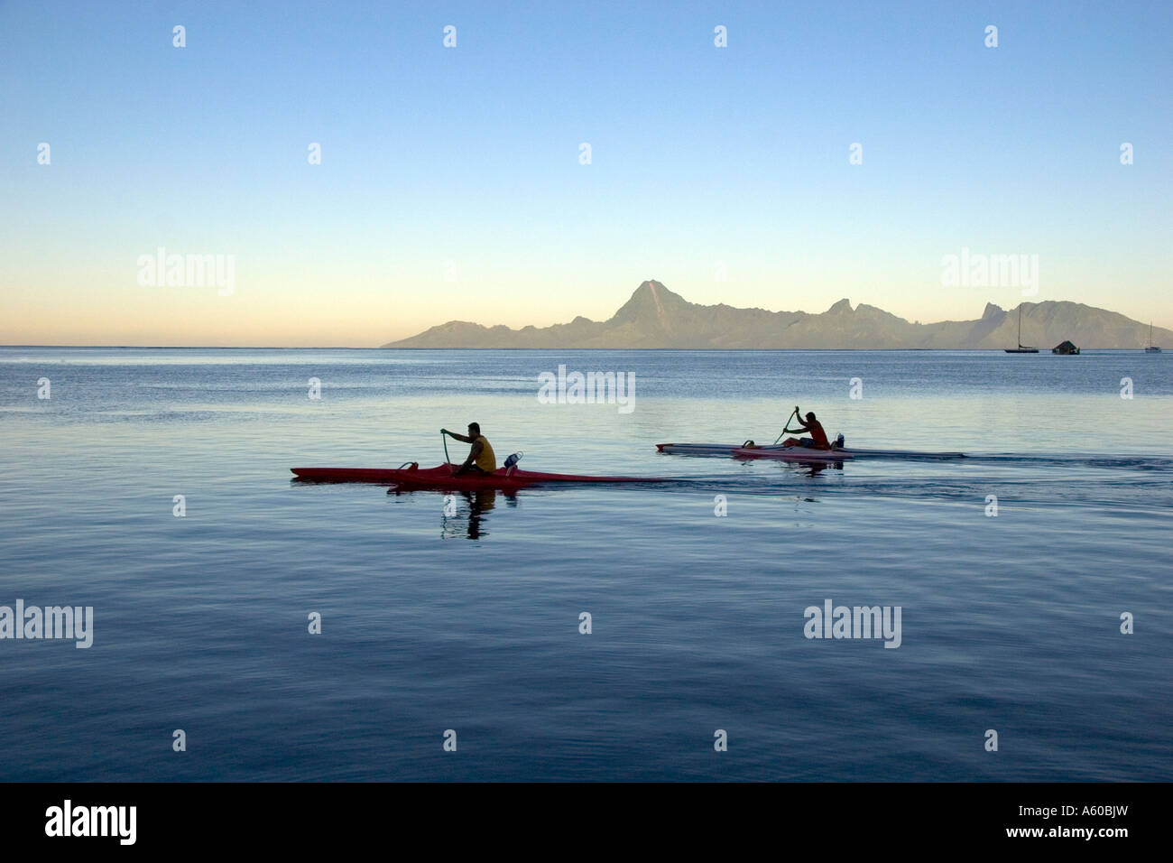 Outrigger canoes at sunrise off the island of Tahiti Stock Photo - Alamy