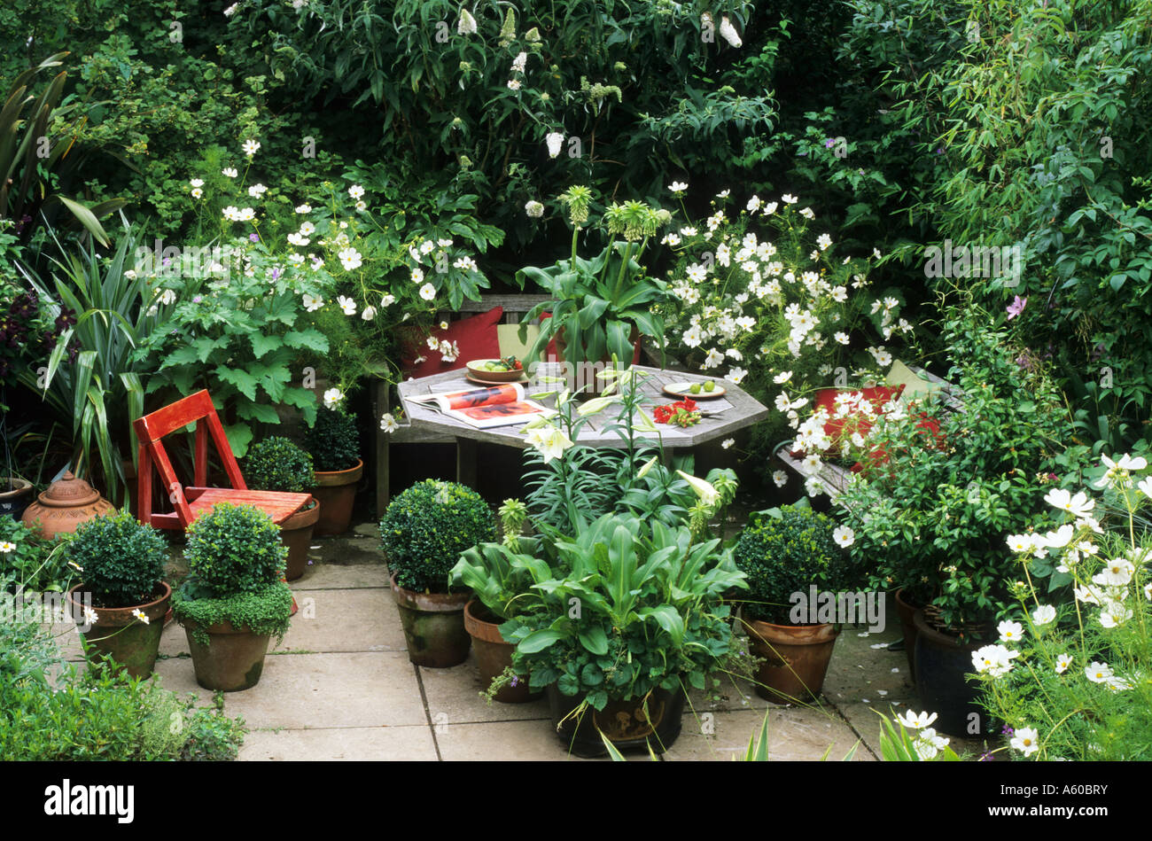Patio table decoration seating red cushions Stock Photo - Alamy