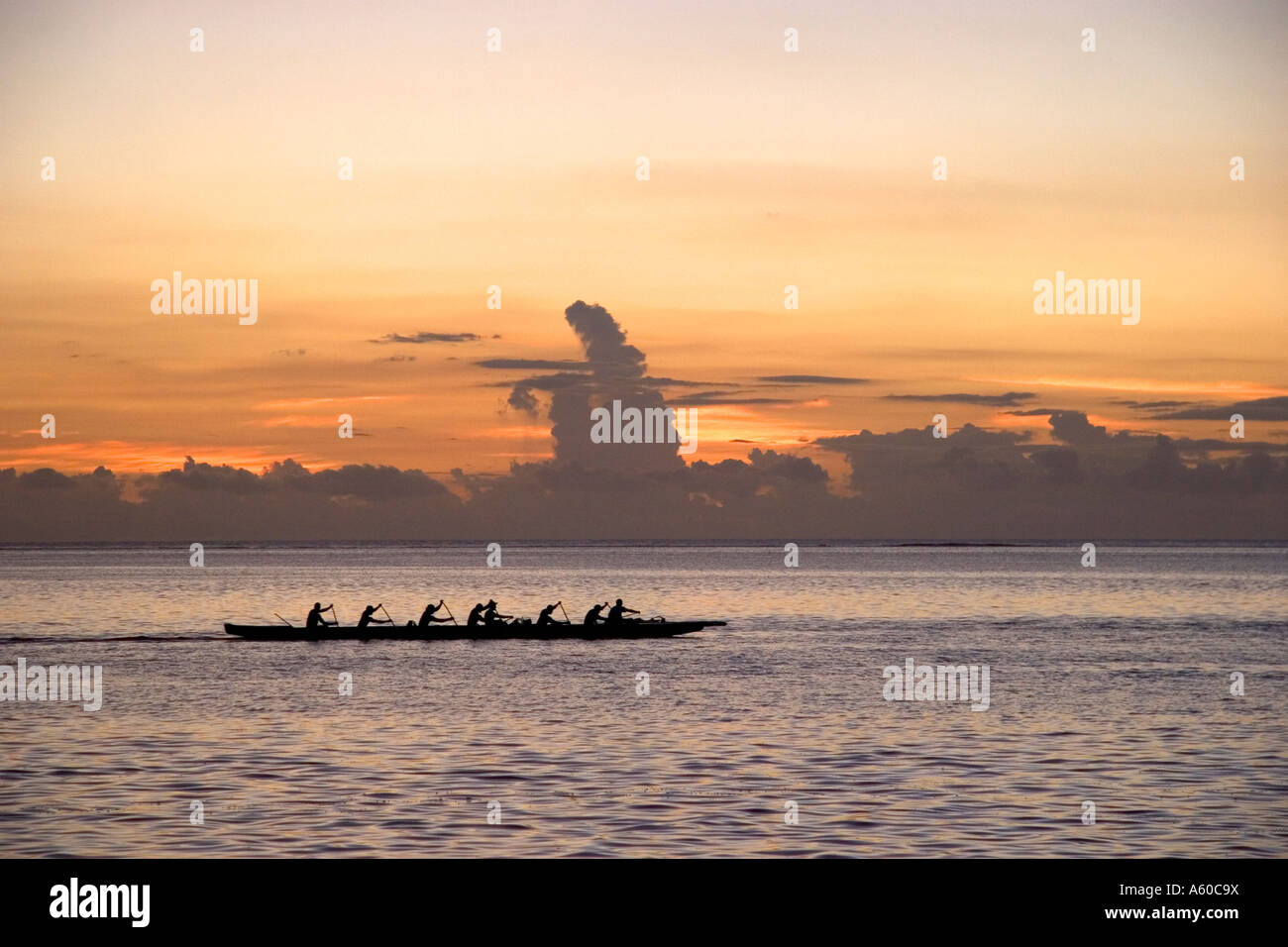 Outrigger canoeing at sunset off the island of Tahiti Stock Photo - Alamy