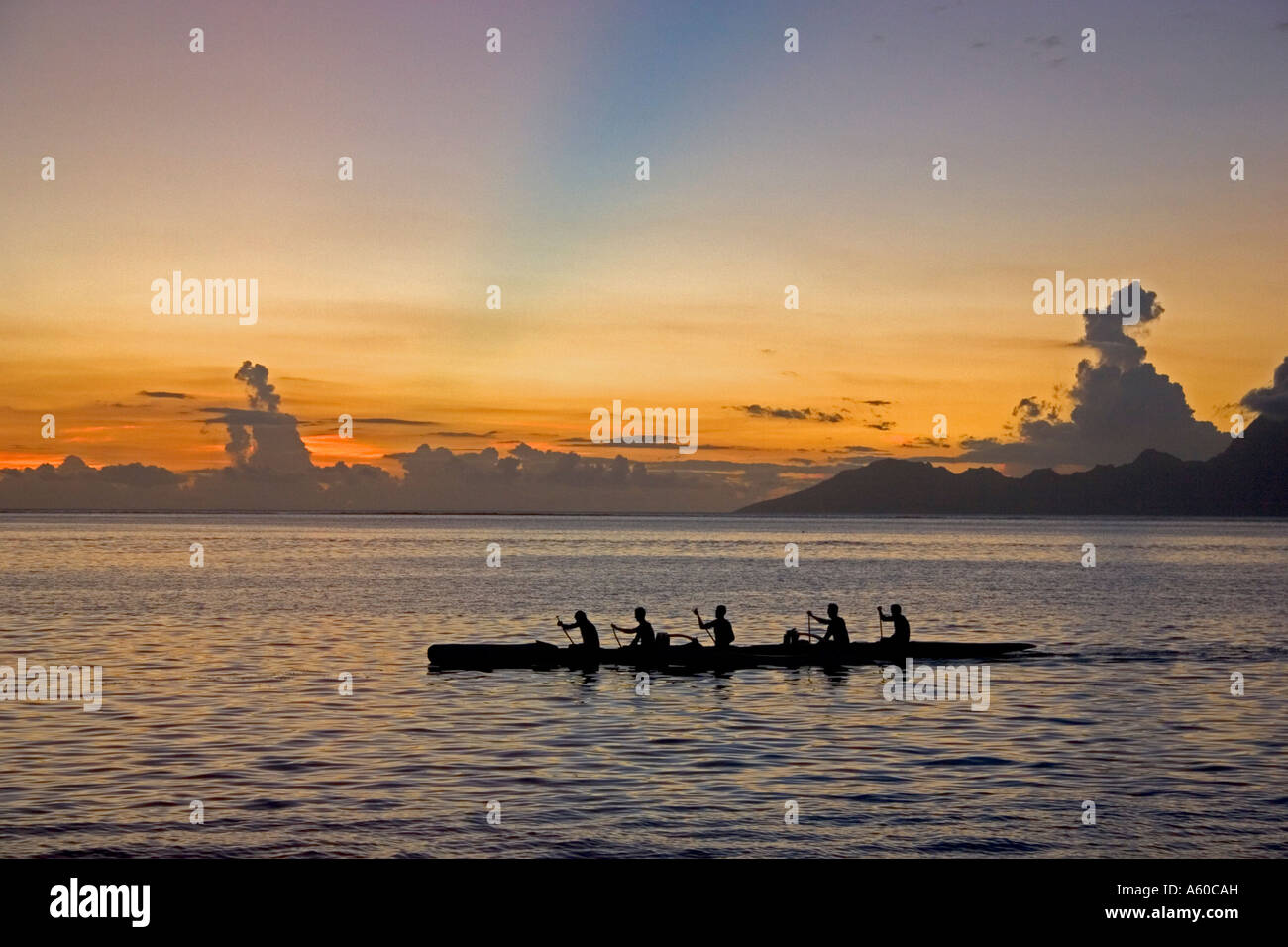 Outrigger canoeing at sunset off the island of Tahiti Stock Photo - Alamy