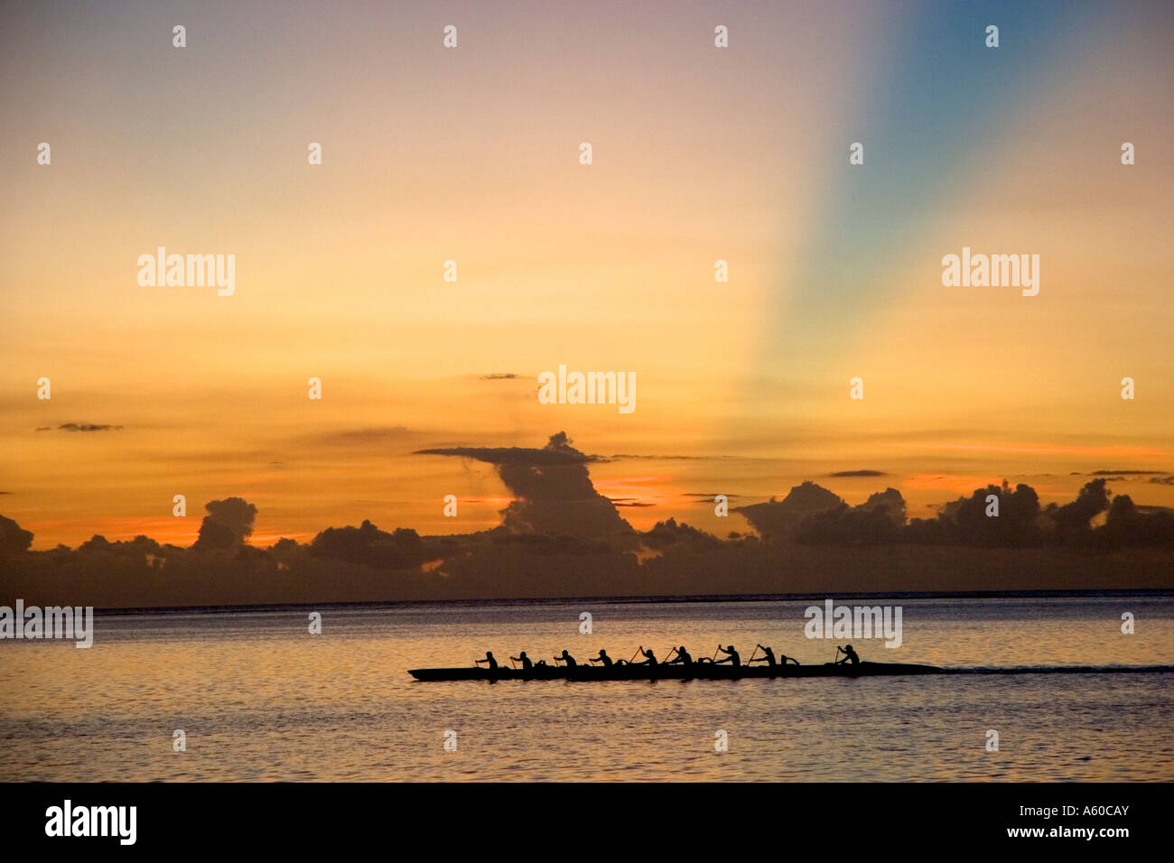 Outrigger canoeing at sunset off the island of Tahiti Stock Photo - Alamy