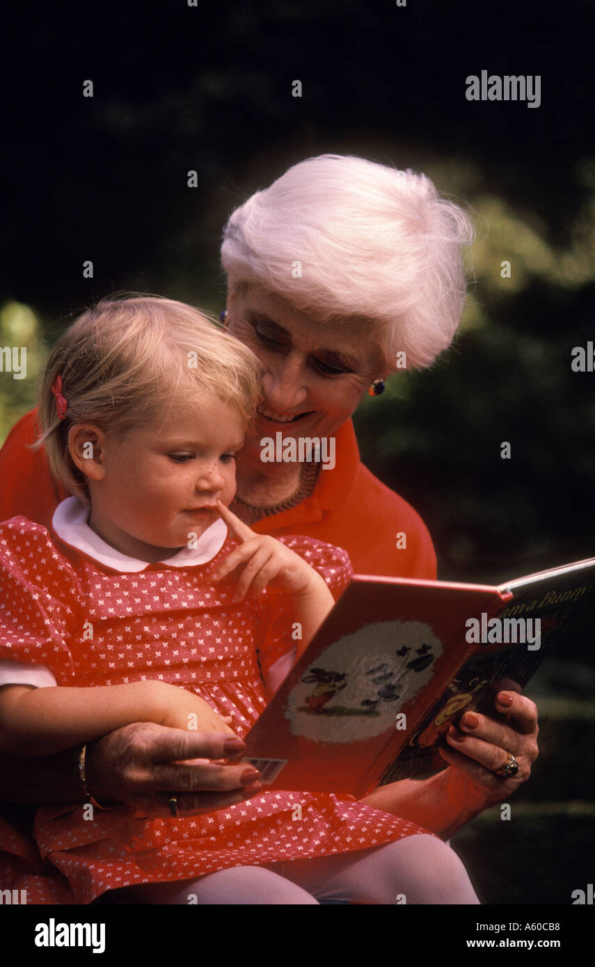 female child sitting on senior womans lap reading Stock Photo - Alamy