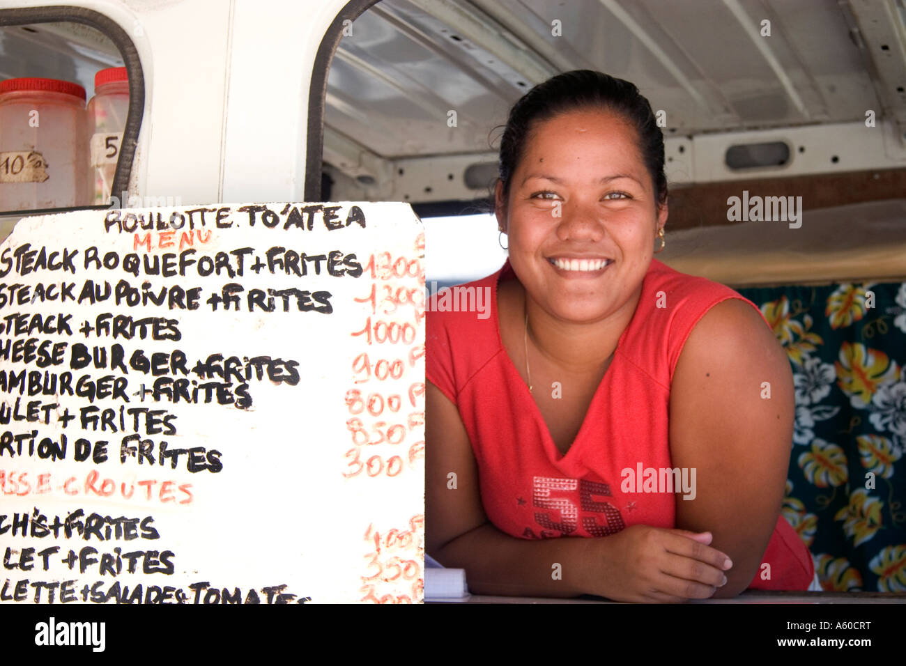 Tahitian woman working at a roulotte food van on the island of Moorea ...