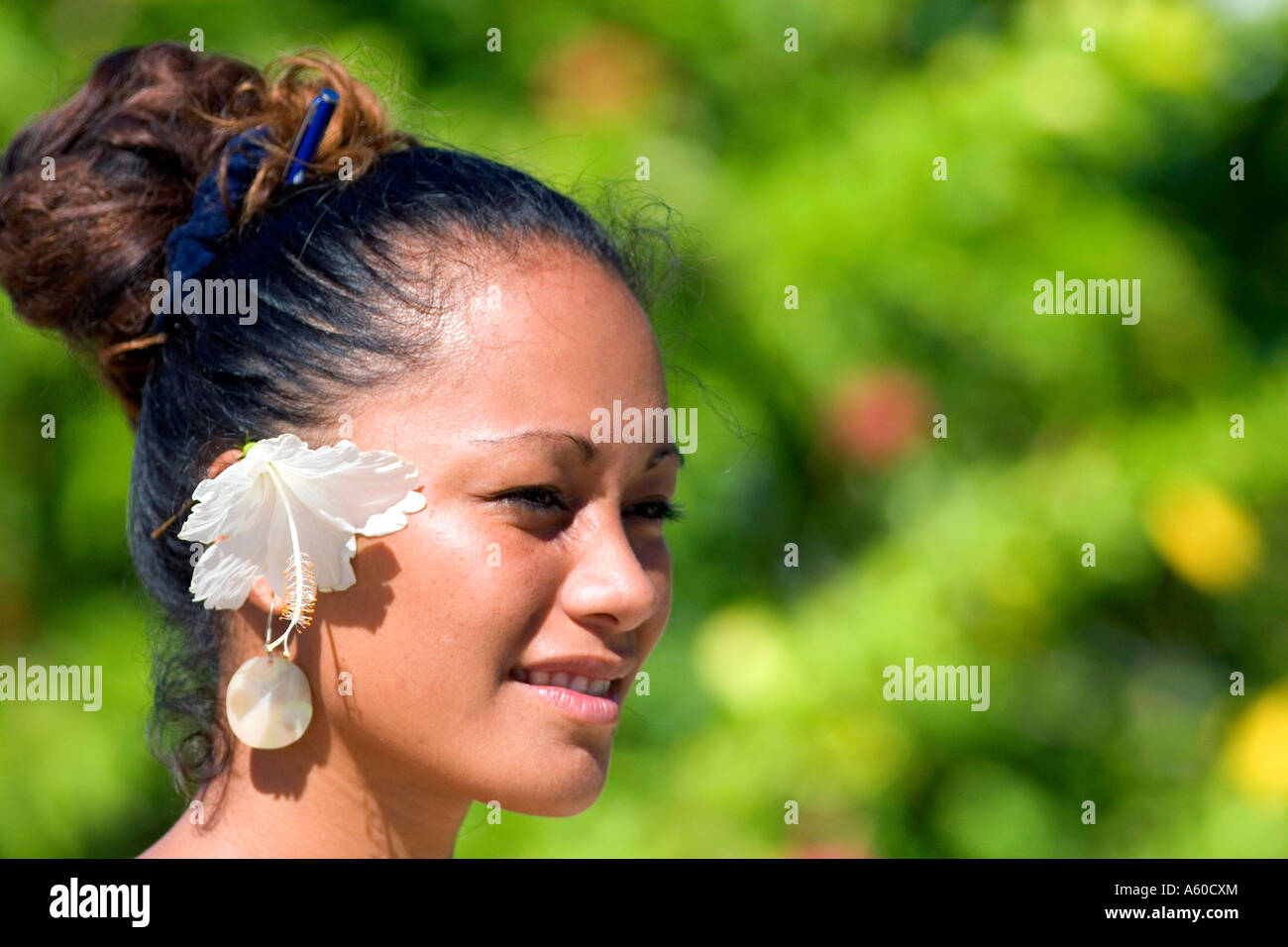 Tahitian woman wearing a tropical flower in her hair on the island of ...