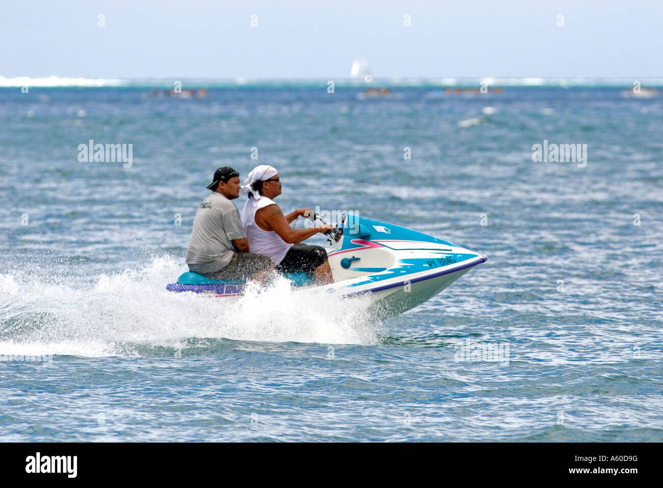 Tahitian men ride a jetski in the lagoon off the island of Moorea Stock ...