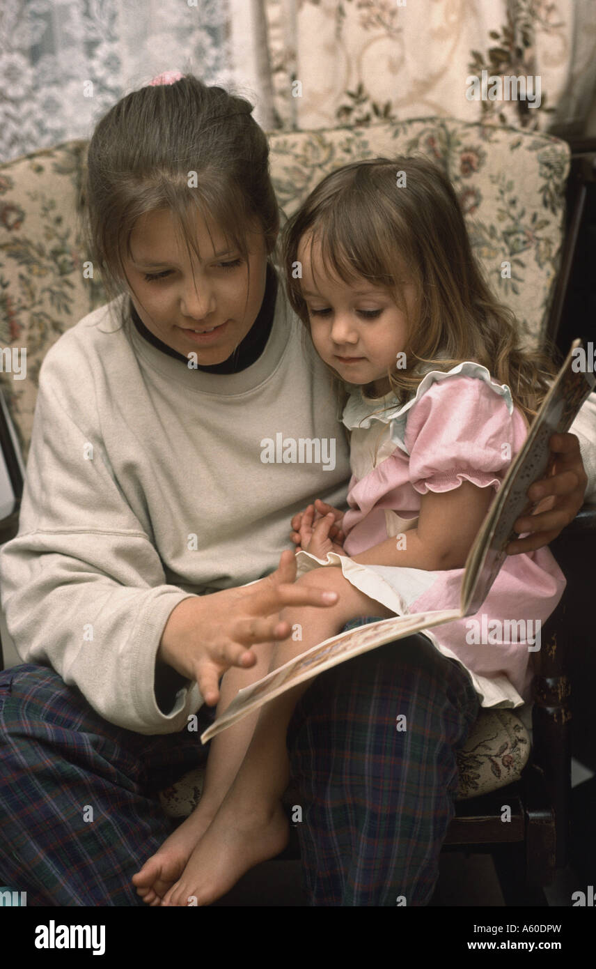 young baby-sitter reading child a book Stock Photo - Alamy