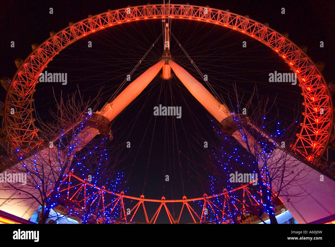Horizontal close up of the London Eye, aka Millennium Wheel lit up red ...