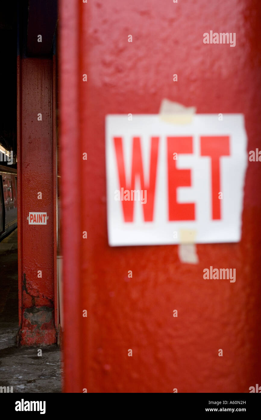 Wet paint signs on subway platform Stock Photo - Alamy