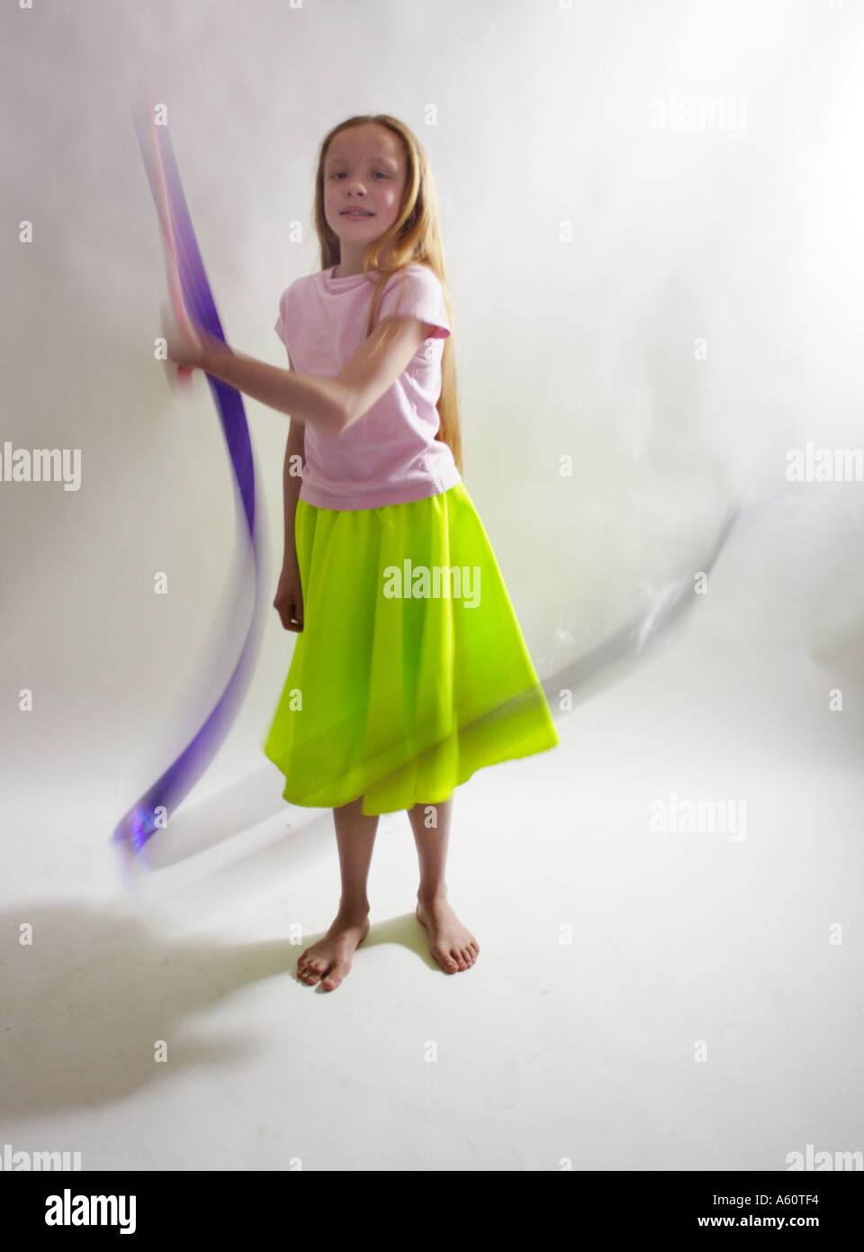Young girl age 10 with ribbon during exercise happy Stock Photo - Alamy