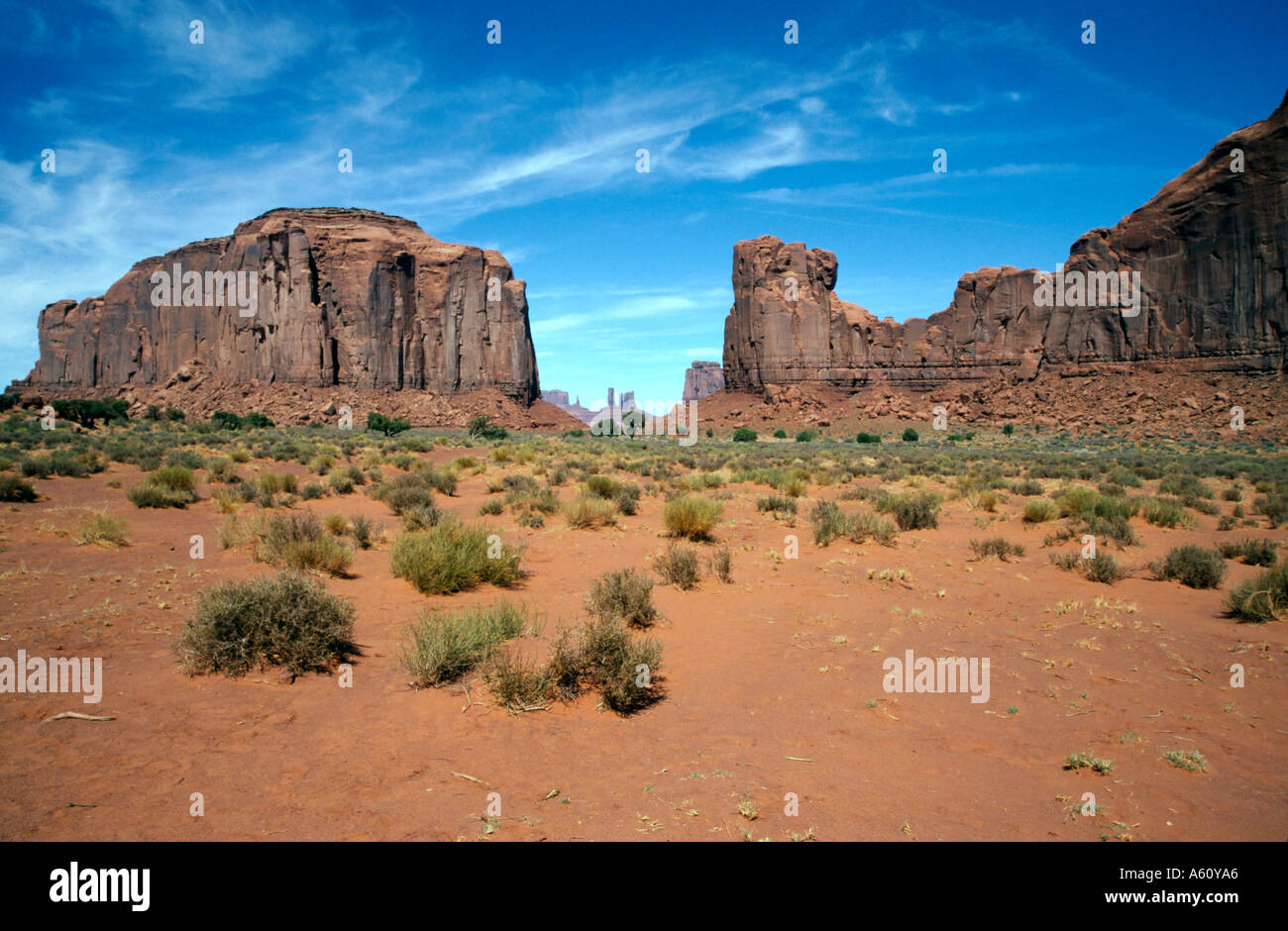 SAndstone Buttes rising above the orange red sands of the desert floor ...