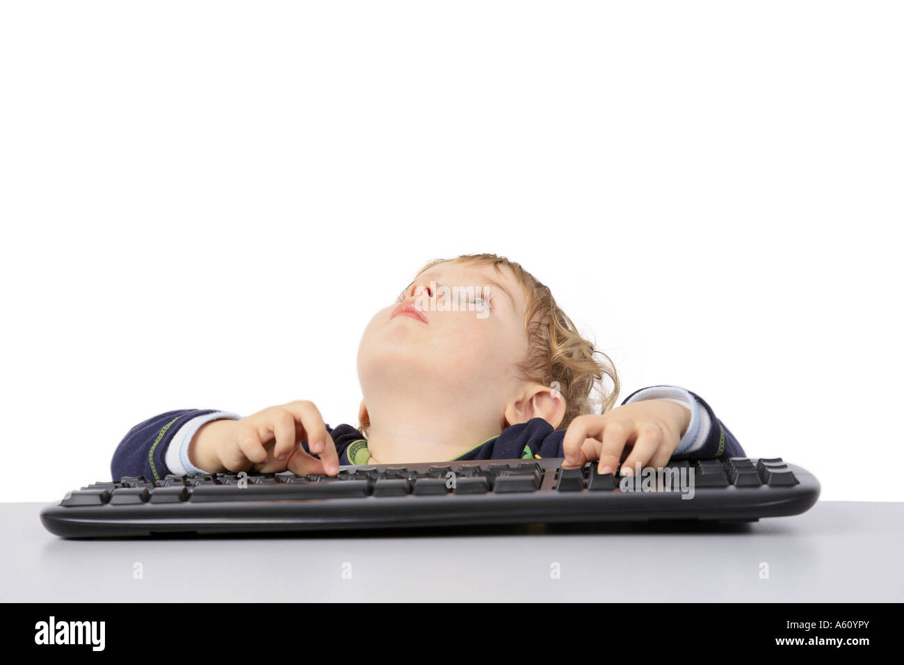 small boy with computer keyboard, looking upwards Stock Photo - Alamy