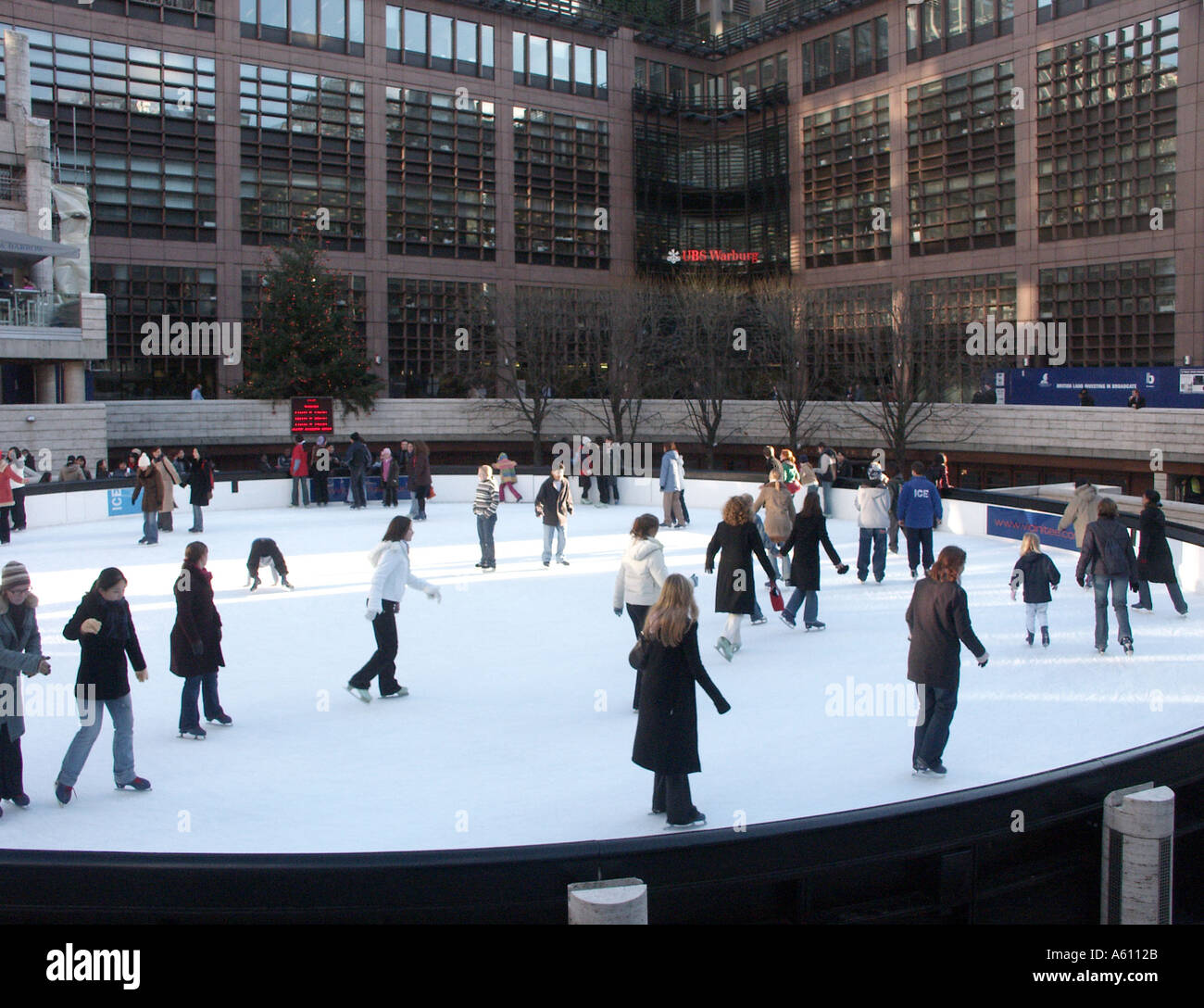 Ice skating rink people on winter public outdoor circular route with ...