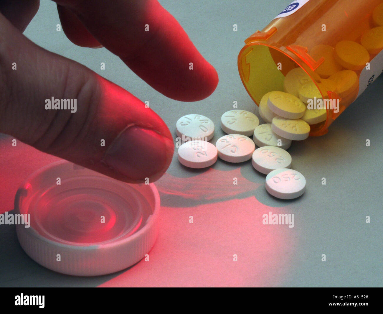 Cipro Tablets with fingers reaching for a pill and pills are spilling ...