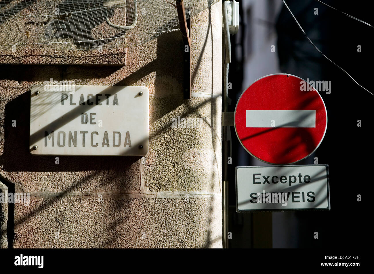 Old Placeta de Montcada street sign on wall next to modern no entry ...