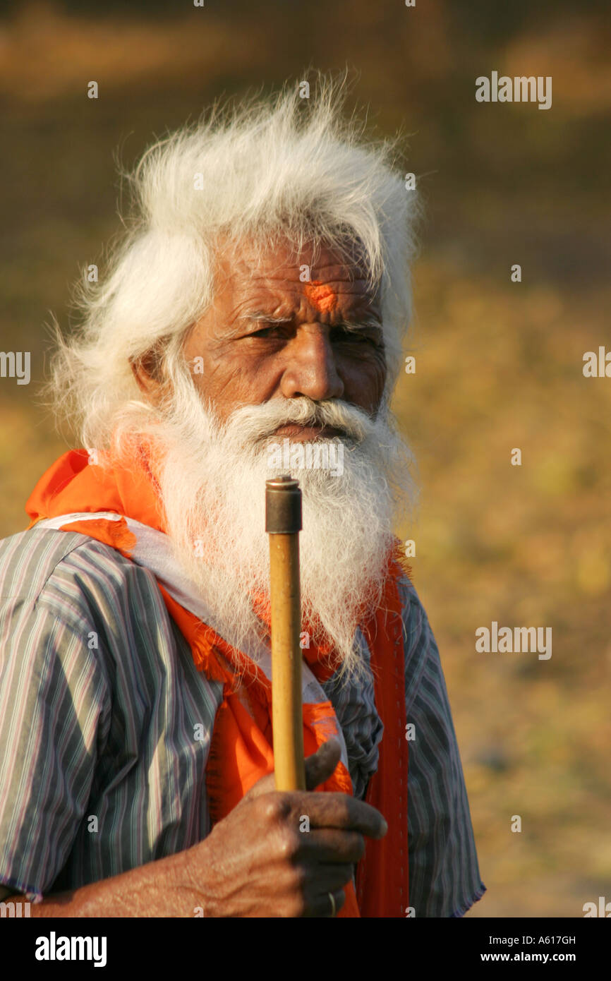White haired bearded Holy Man walking with his staff walking through ...