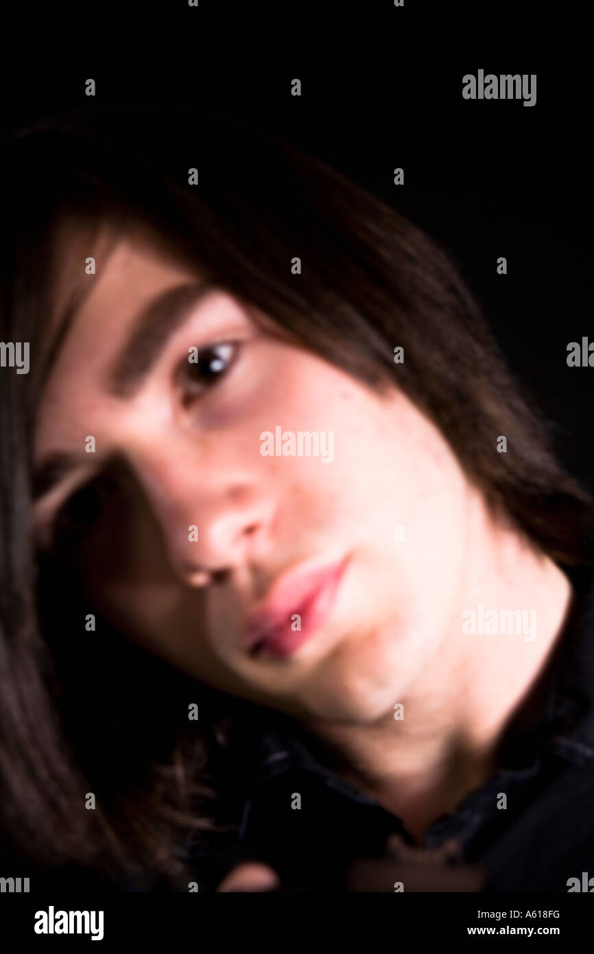 Blurred image of face only of a young boy looking questioningly aged 16 ...