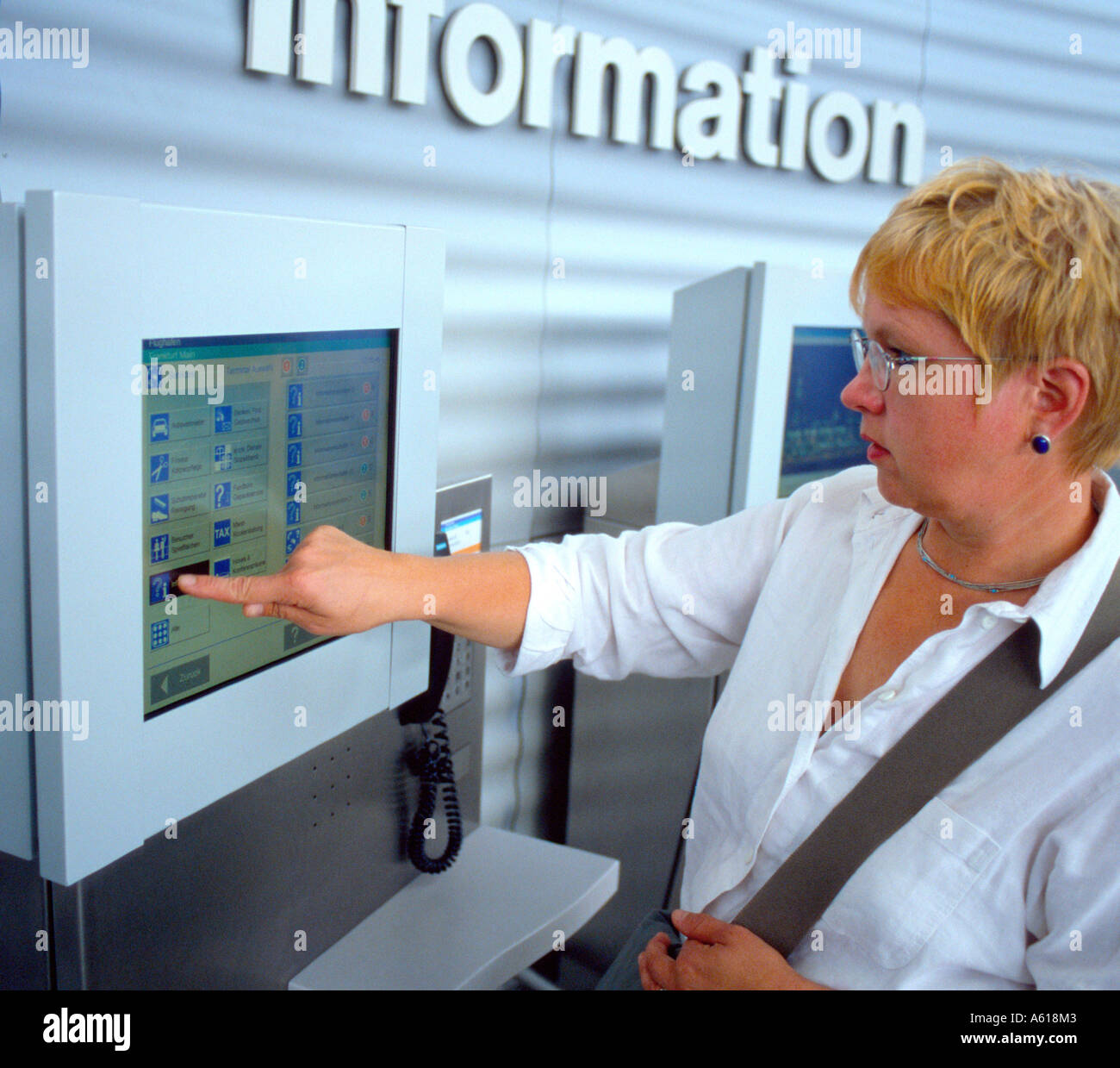 Woman using touch screen information machine Stock Photo - Alamy