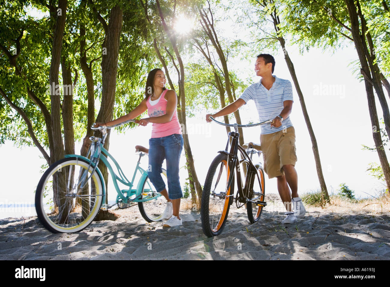 Pacific Islander couple walking bicycles on beach Stock Photo - Alamy