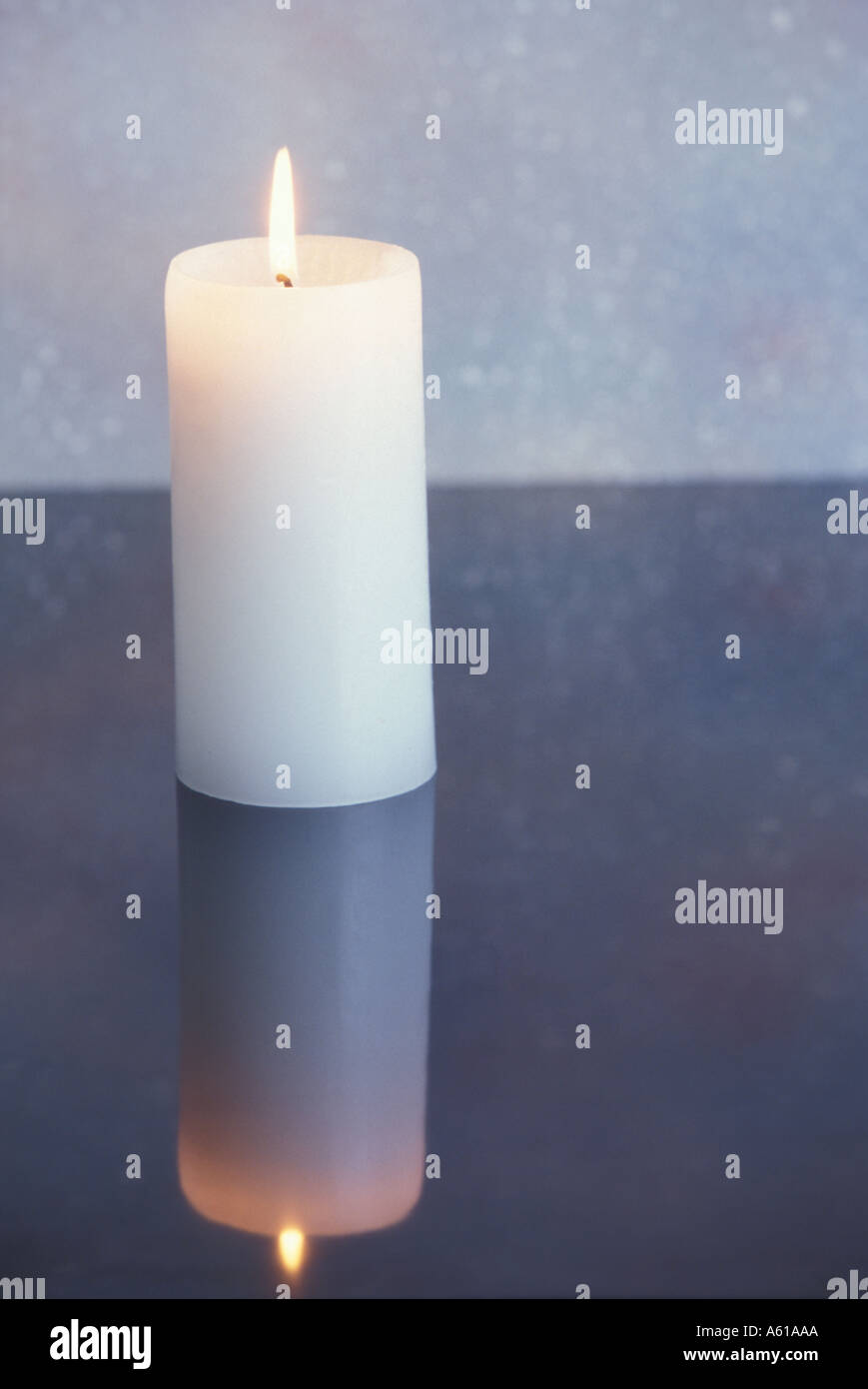 Burning candle reflecting in table Stock Photo - Alamy