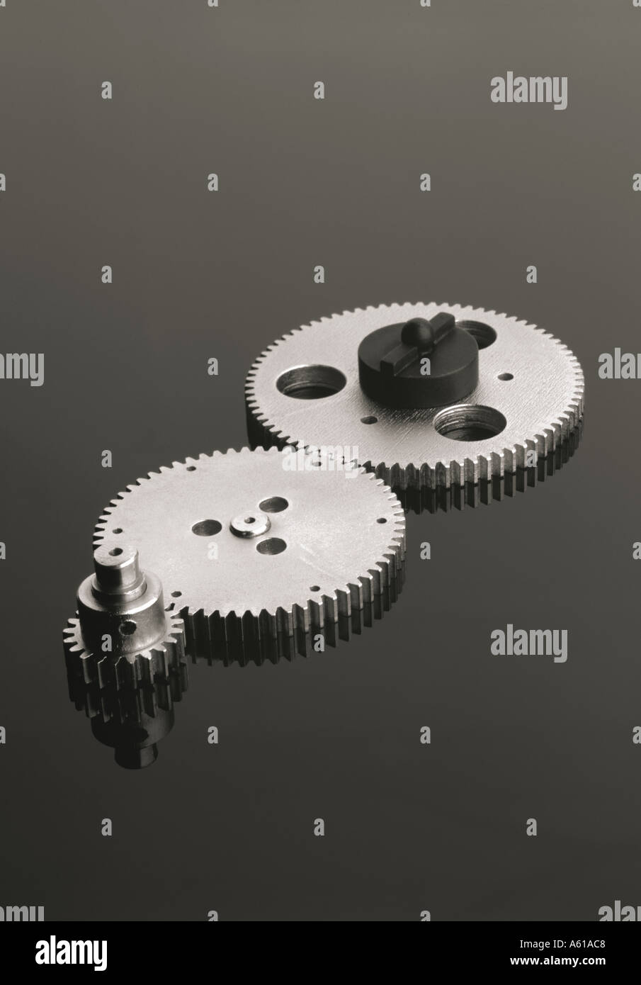Synchronized gears on black plexiglass connected Stock Photo - Alamy