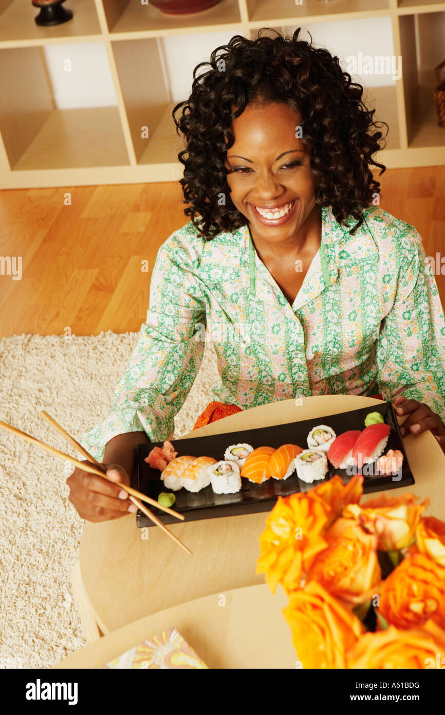 African woman eating sushi at home Stock Photo - Alamy