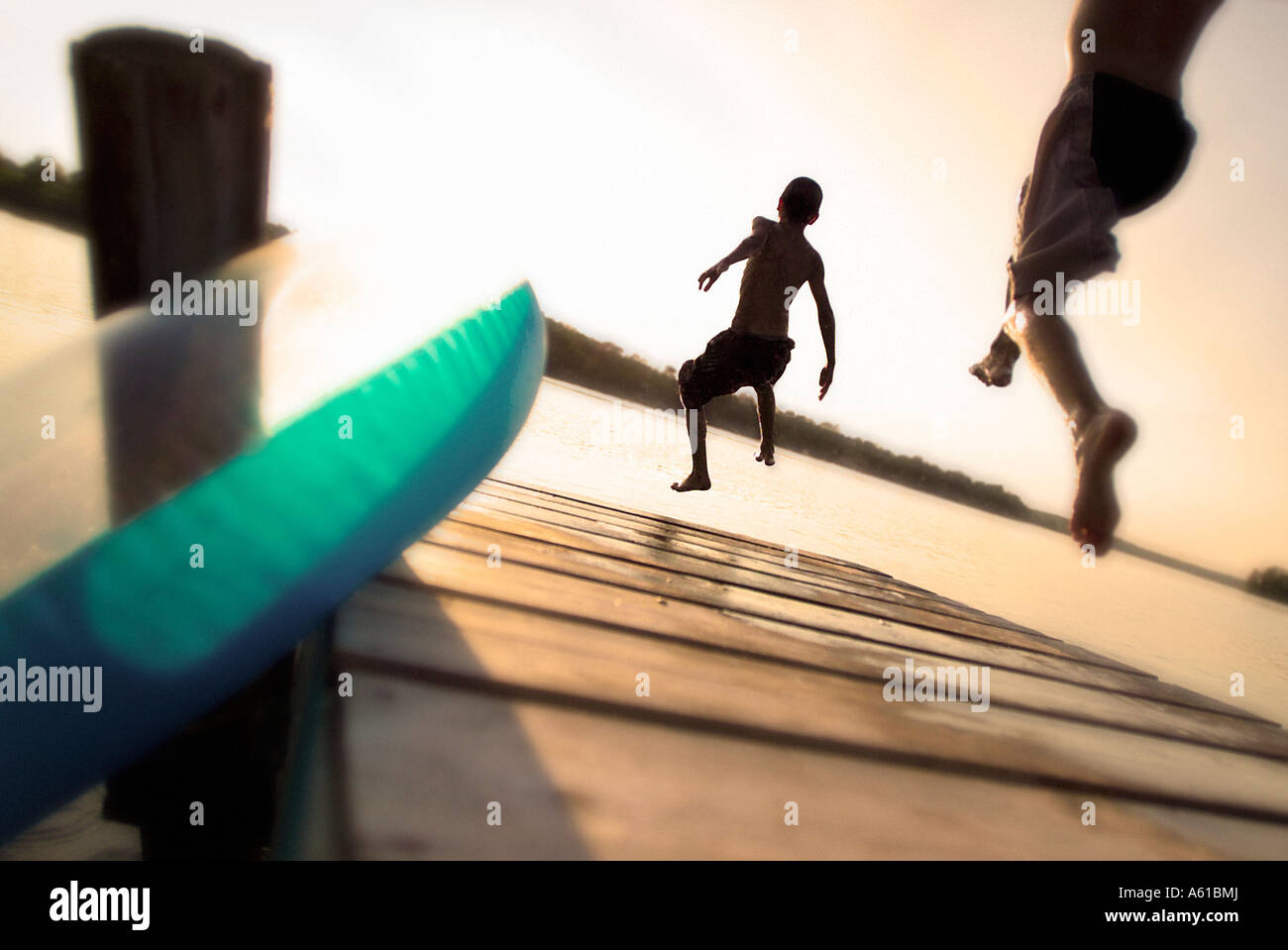 Boys Jumping off a dock Stock Photo - Alamy