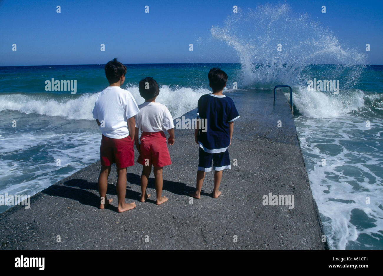 Children watching waves in sea Stock Photo - Alamy