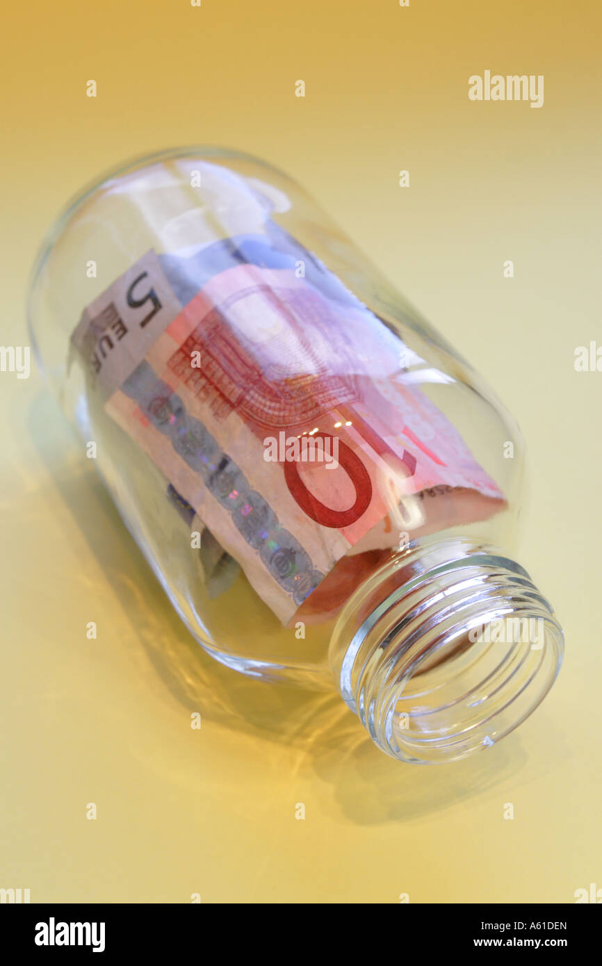 Saving money 10 Euro banknote in glass savings jar Stock Photo - Alamy