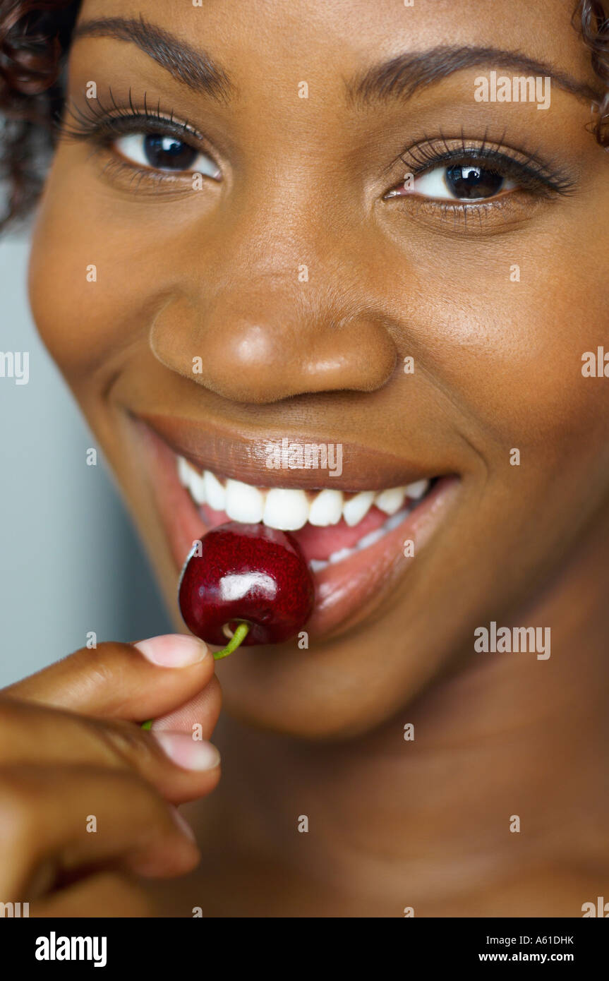 Close up of African woman eating cherry Stock Photo - Alamy