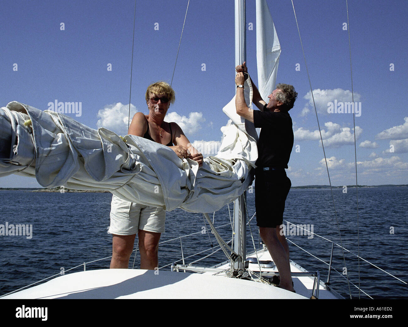 man and womansetting sails on sailing yacht Stock Photo - Alamy