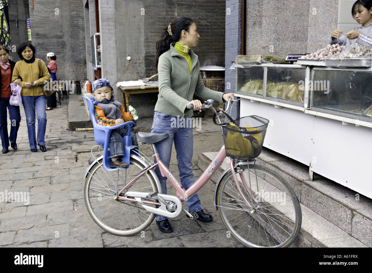 CHINA XIAN Young Chinese mother with her baby in a bicycle seat Stock ...