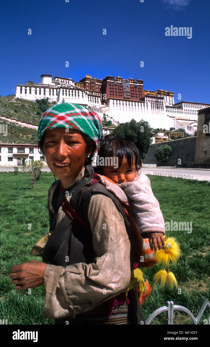 Native woman with child on her back in rural country outside the city ...