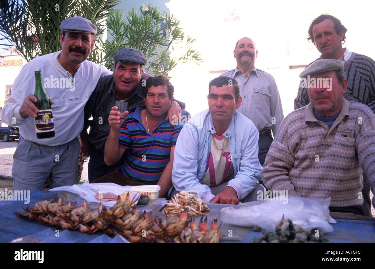 Tough and rough old fishermen relaxing at a bar in the village of Olmao ...
